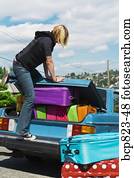 Woman loading car trunk with colorful suitcases Stock Photo | bcp823-49 ...