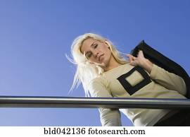 Young boy and young girl leaning over a railing by a lake. Stock Image ...