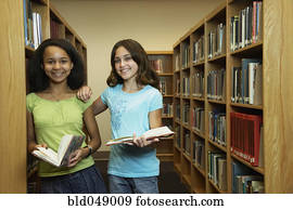 Multi-ethnic girls telling secret in library Stock Photo | bld049008 ...