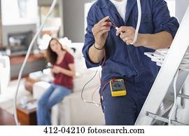 Female electrician talking to client in home Stock Photograph | 412 ...