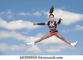 Stock Photo of an ethnic teenage female cheerleader jumps high in the ...