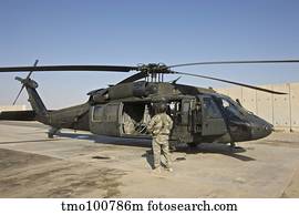 A U. S. Army UH-60 Black Hawk helicopter prepares to pick up soldiers ...